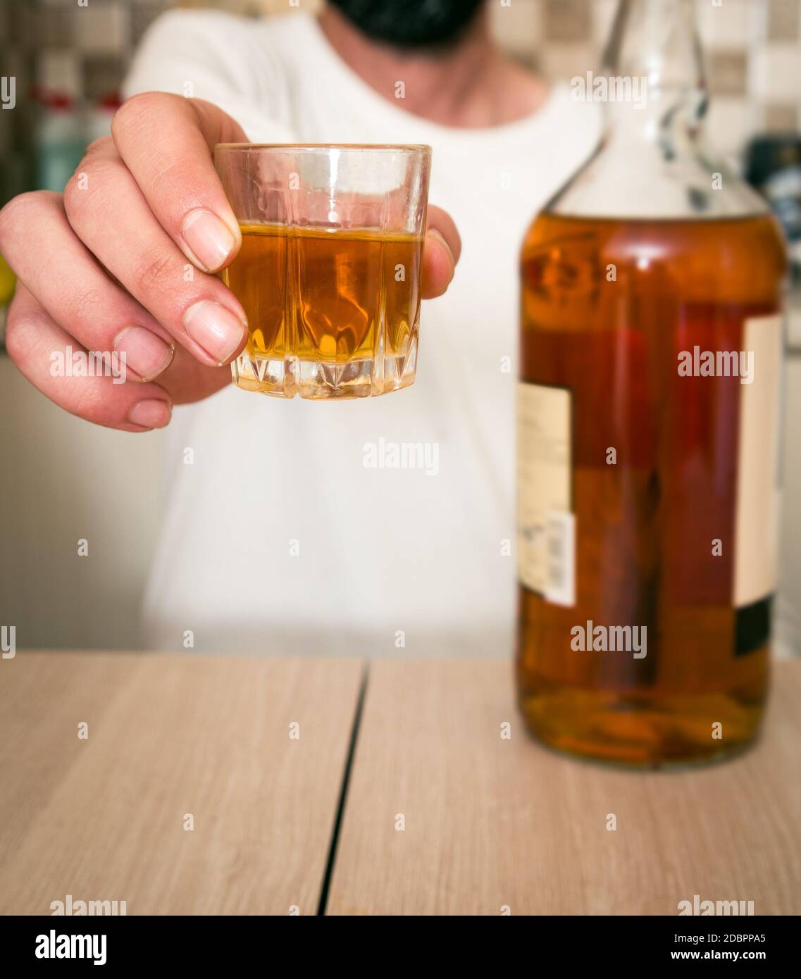 Alcoholic drink and drunken man in kitchen Stock Photo - Alamy