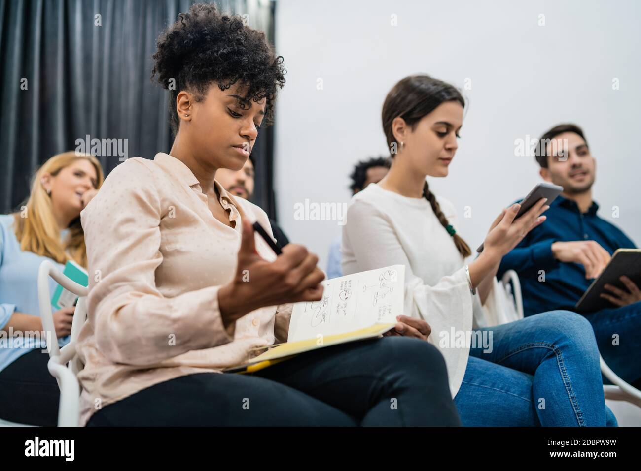 Creative business people listening to colleague Stock Photo - Alamy