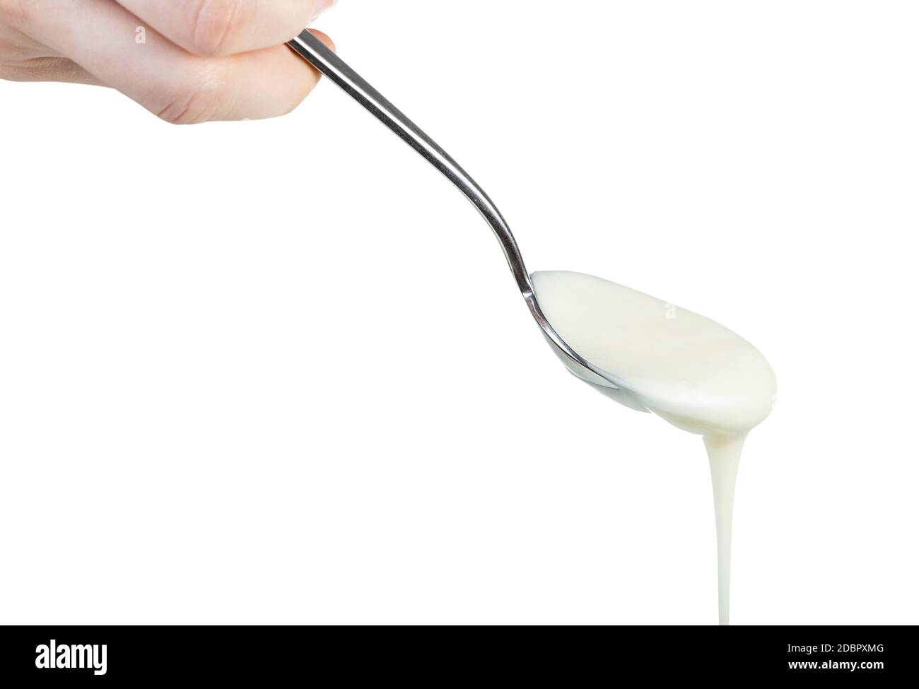 side view of natural organic white honey pouring from steel spoon ...