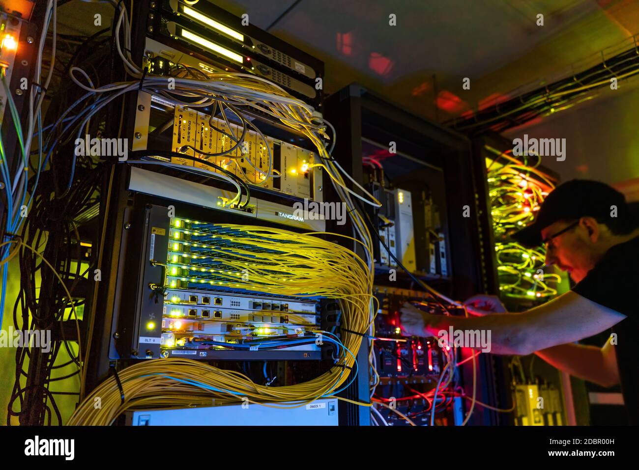 Guy trying to hack servers in cables room Stock Photo - Alamy