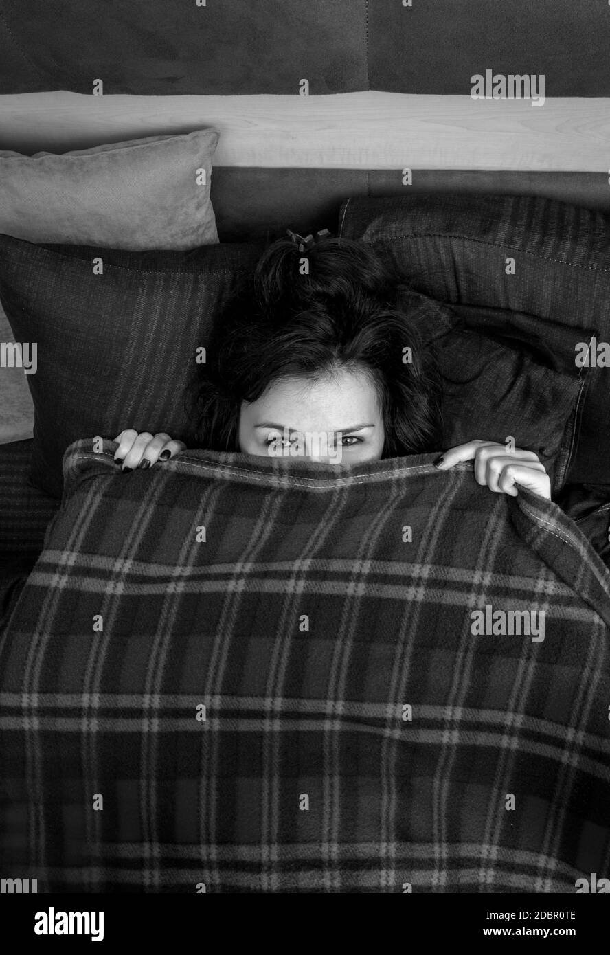 Brunette woman under the blanket Stock Photo - Alamy