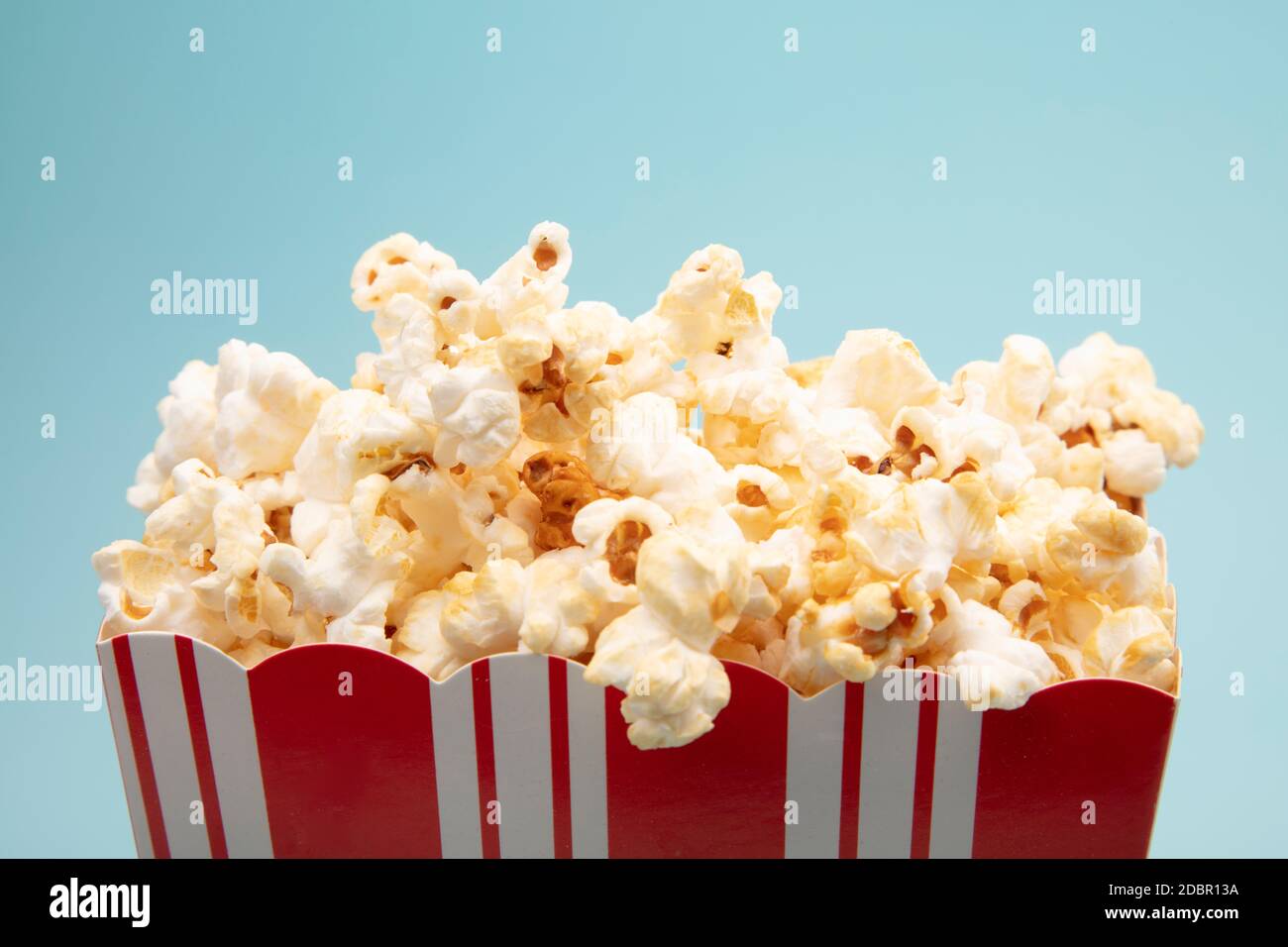 Large paper cup filled with salted Pocorn on bright blue Background ...