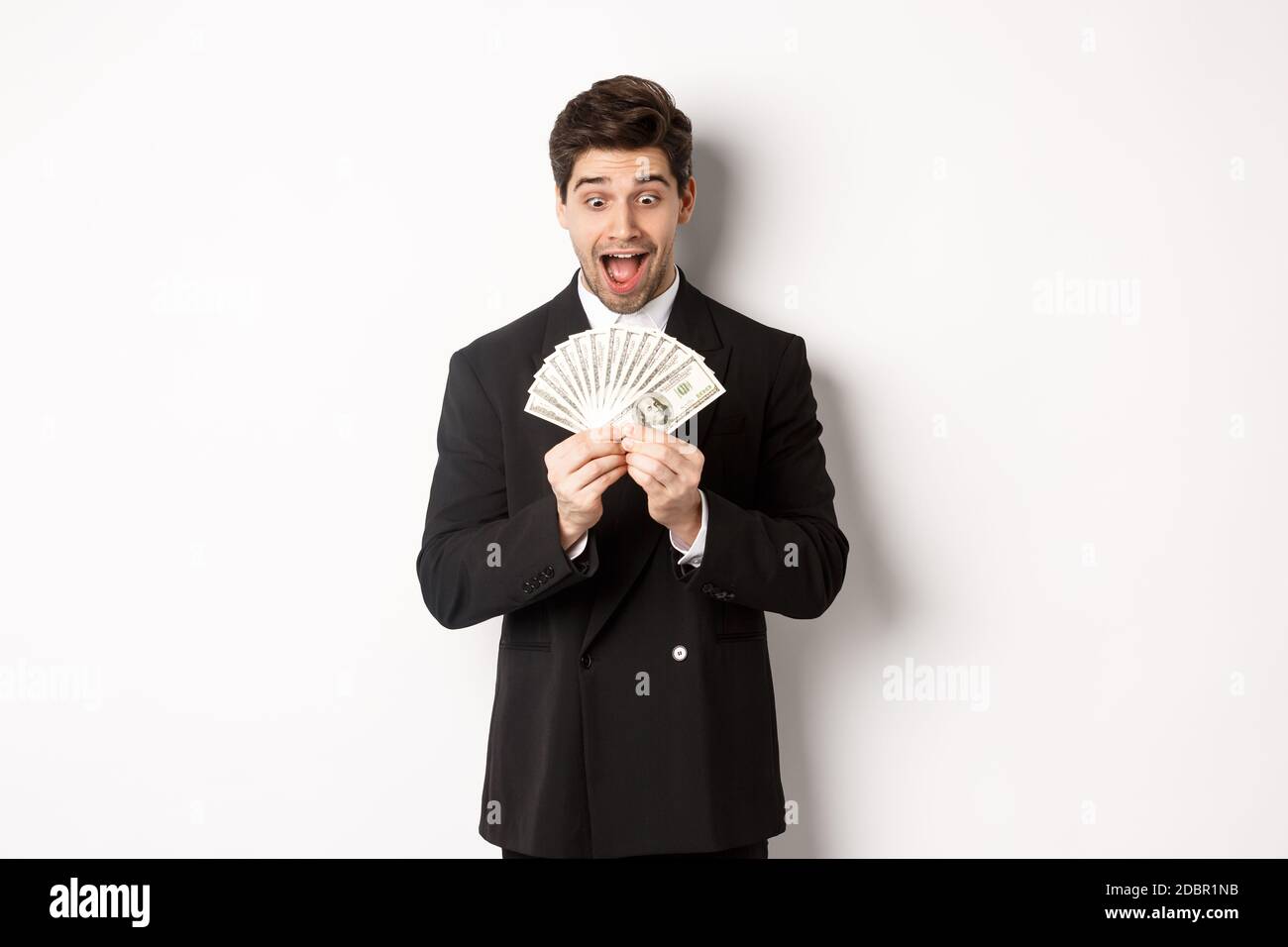 Image of handsome bearded guy in black suit, looking at money with ...