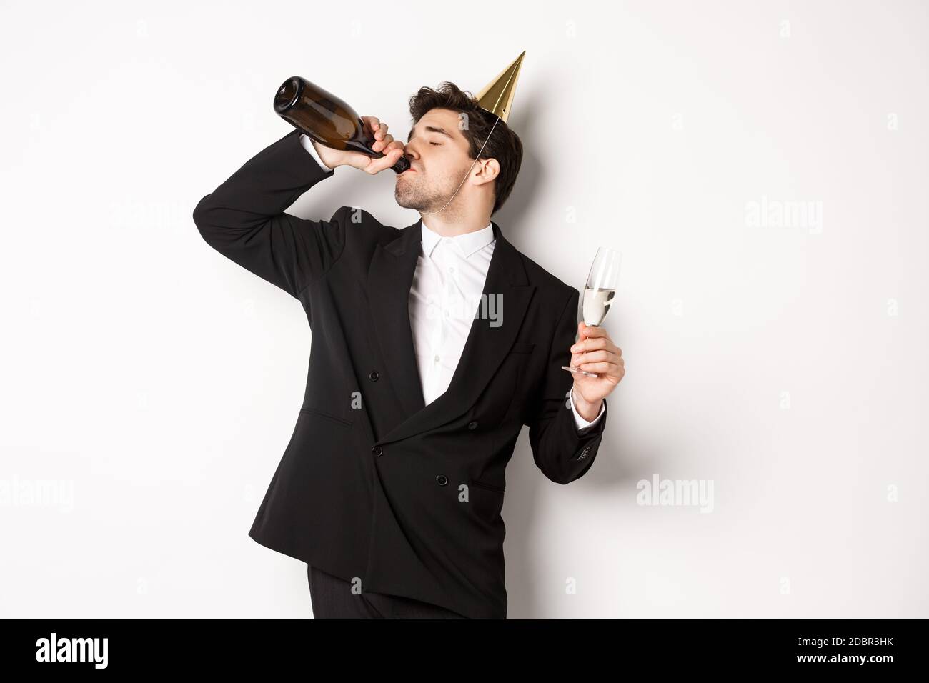 Image of handsome guy in trendy suit, drinking champagne from bottle ...