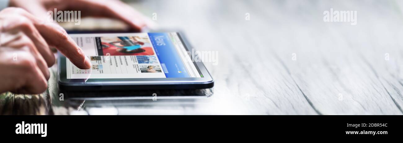 Reading Newspaper Article Online On Digital Tablet Stock Photo - Alamy