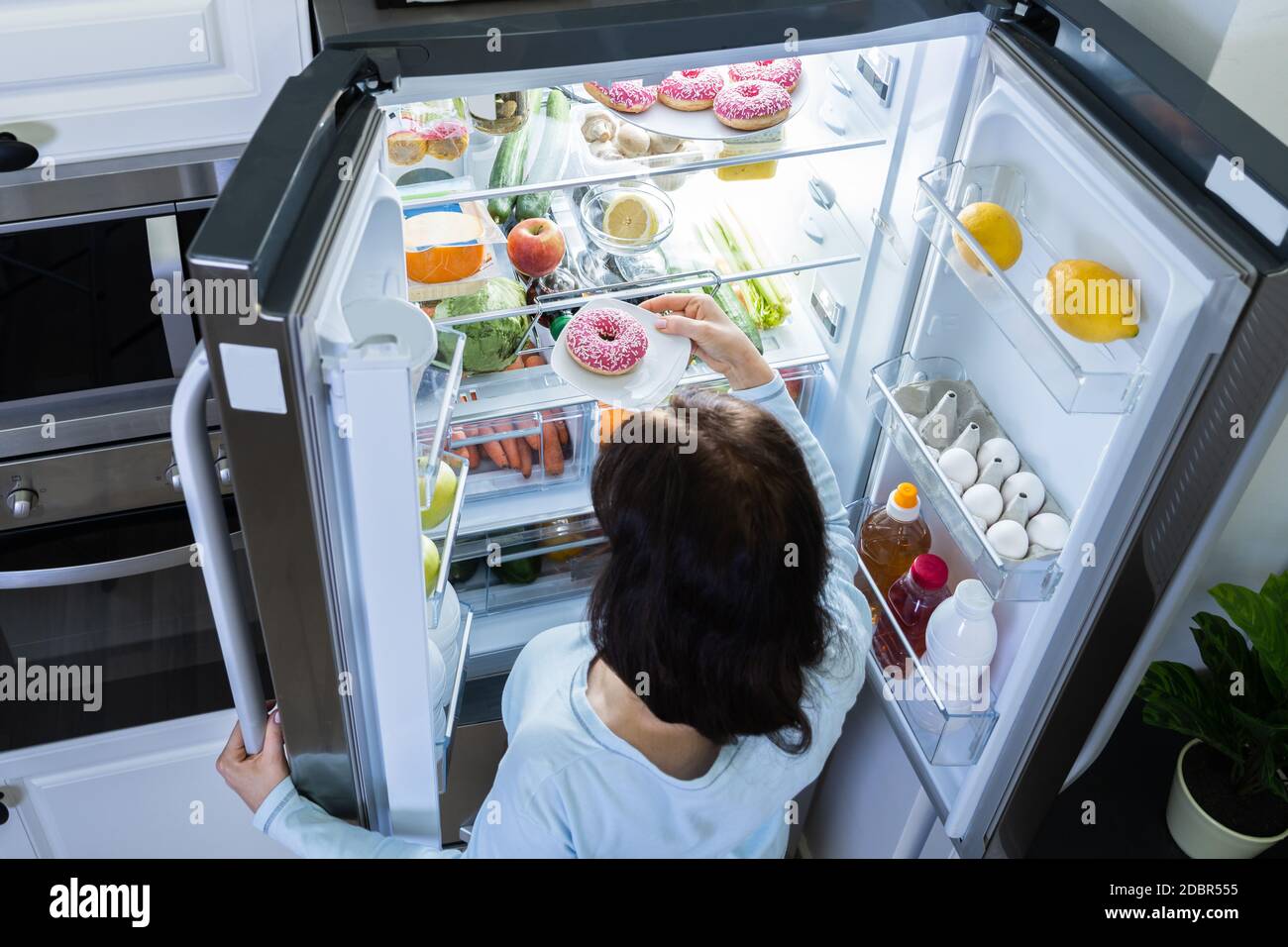 Hungry Woman At Night With Open Fridge Stock Photo - Alamy