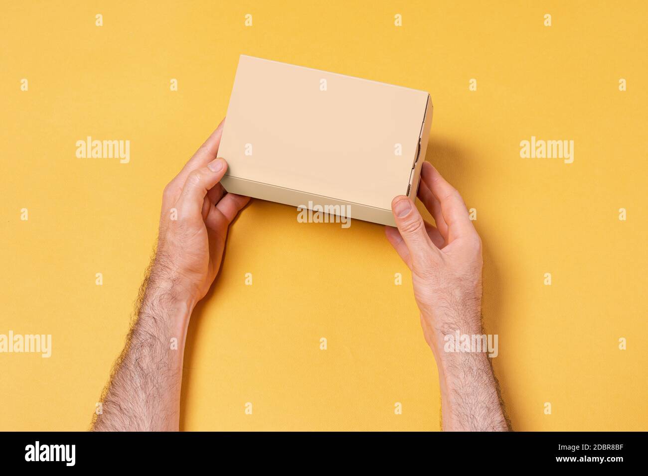 Male hand holding a small gift box, mock-up series template ready for ...