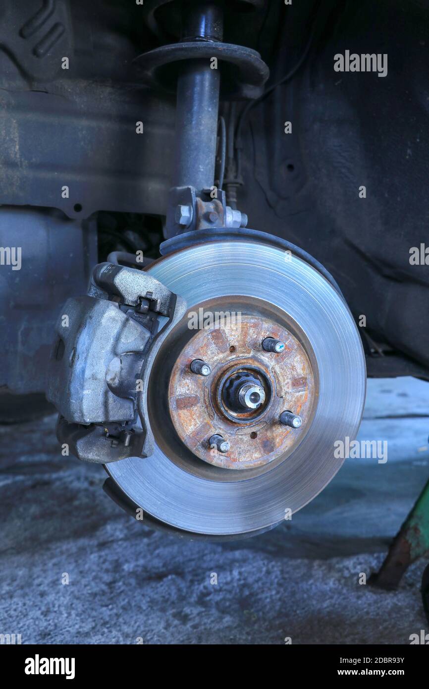 Front disc brake on car in process of new tire replacement. The rim is ...