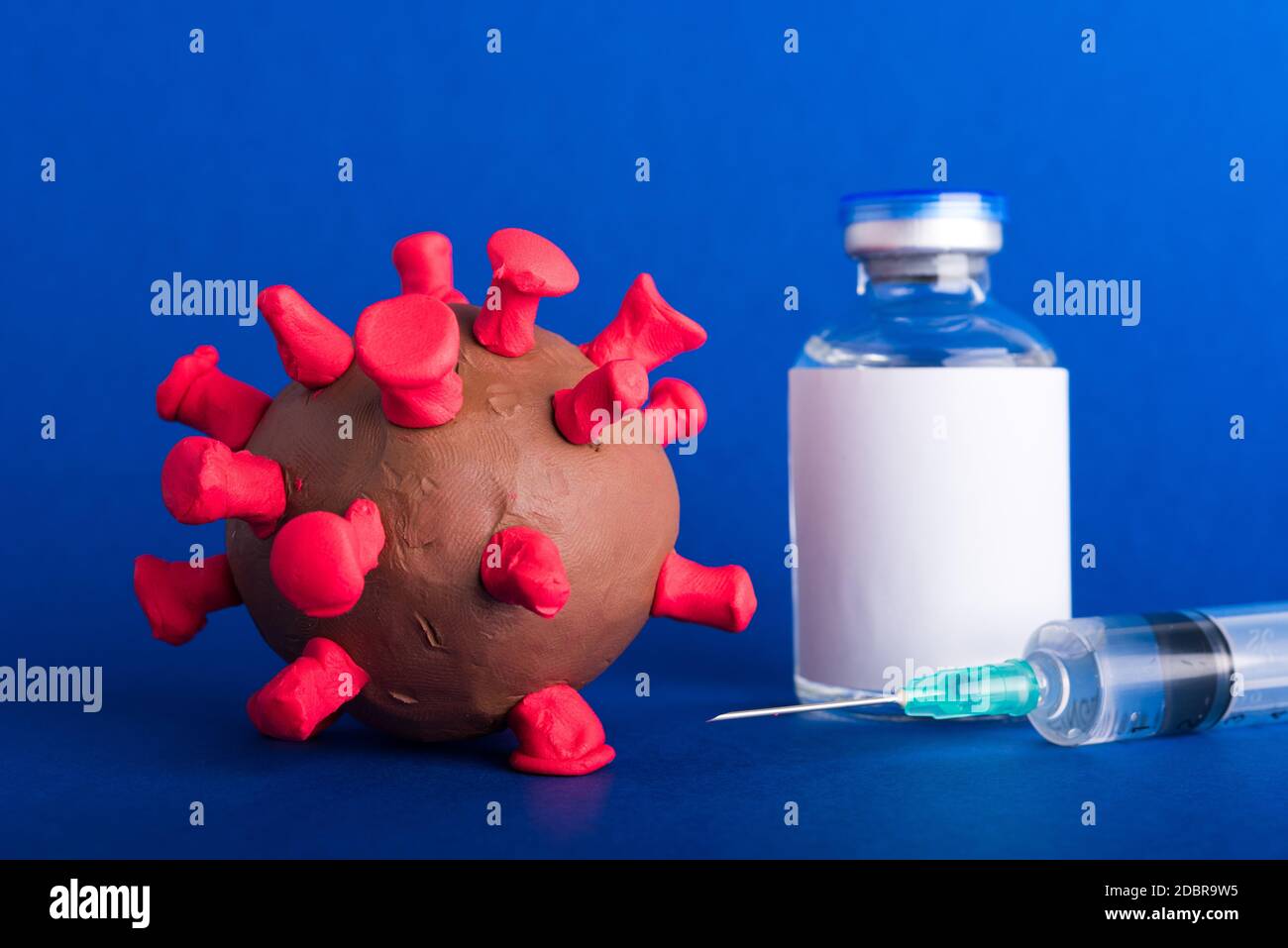 Closeup plasticine disease cells virus bottle vaccine and syringe of ...