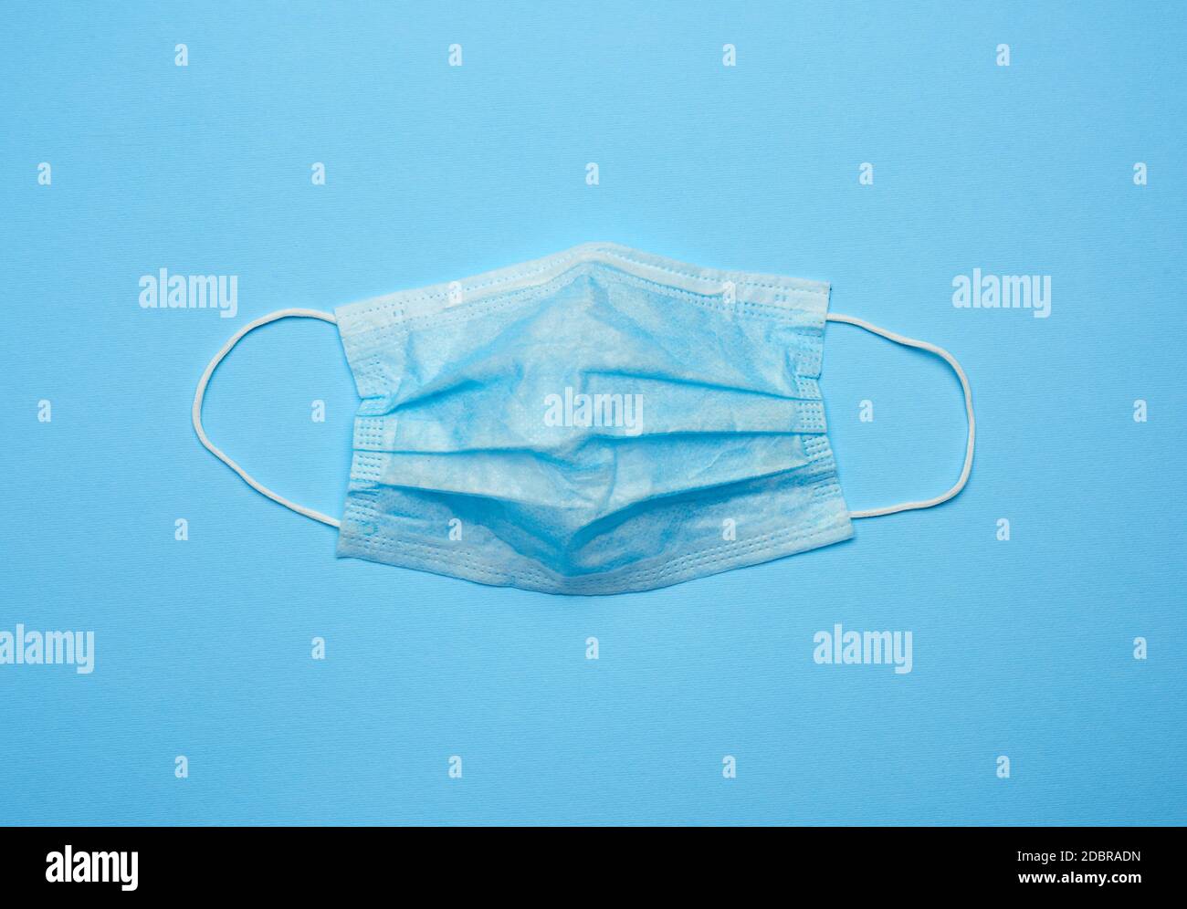 blue disposable medical mask on a blue background, personal protective ...