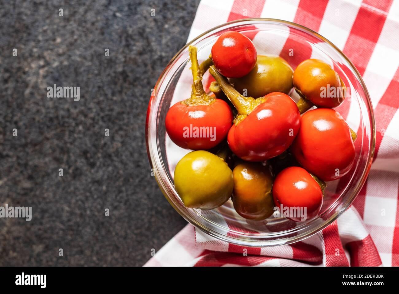 Round chili peppers. Green and red pickled peppers in bowl. Top view ...