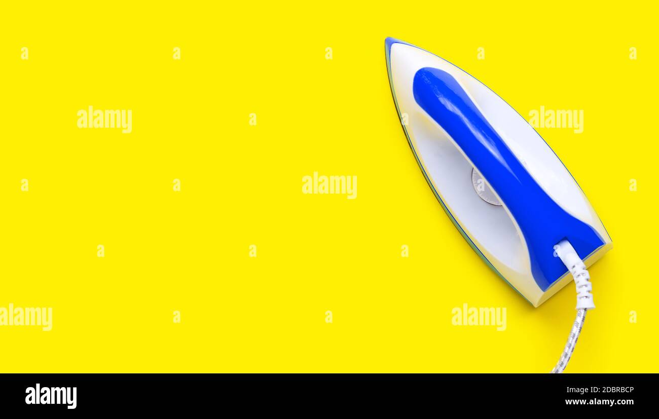 Iron on yellow background. Top view with copy space Stock Photo - Alamy
