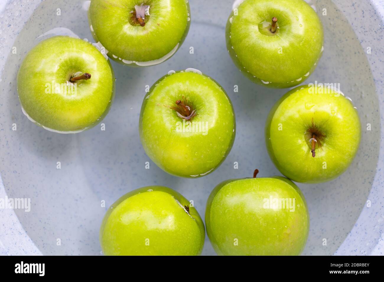Soak green apples in water. Washing fruit concept. Top view Stock Photo ...