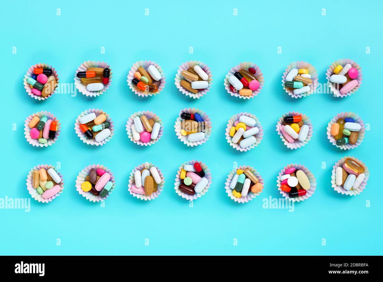 Colorful tablets with capsules and pills in cupcake wrappers on blue ...
