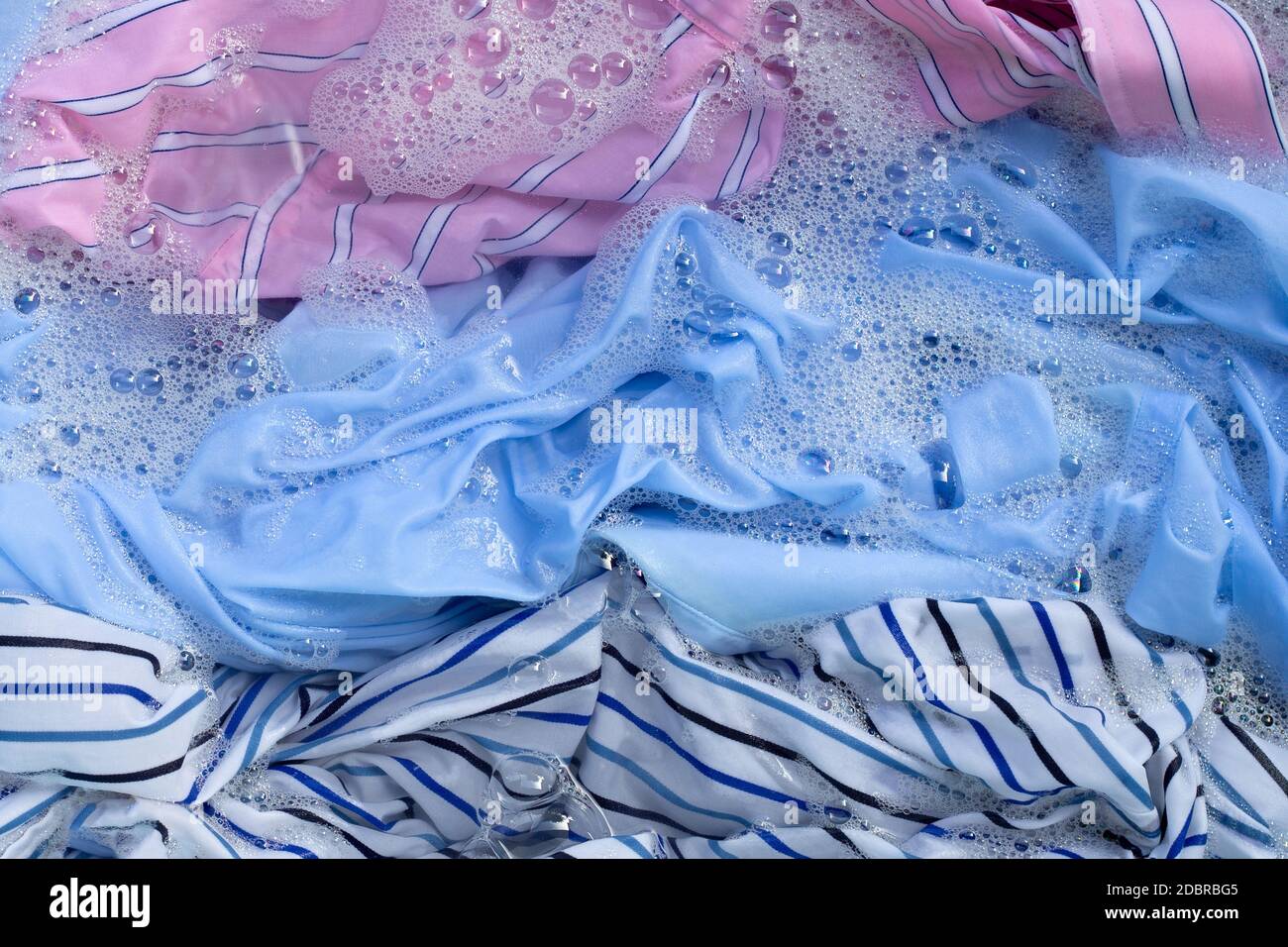 Top view of color clothes soak in powder detergent water dissolution ...