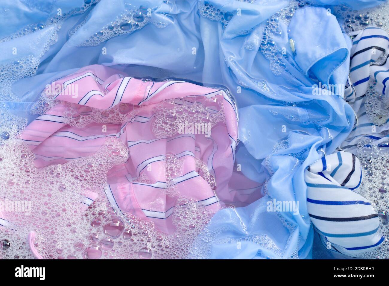Top view of color clothes soak in powder detergent water dissolution ...