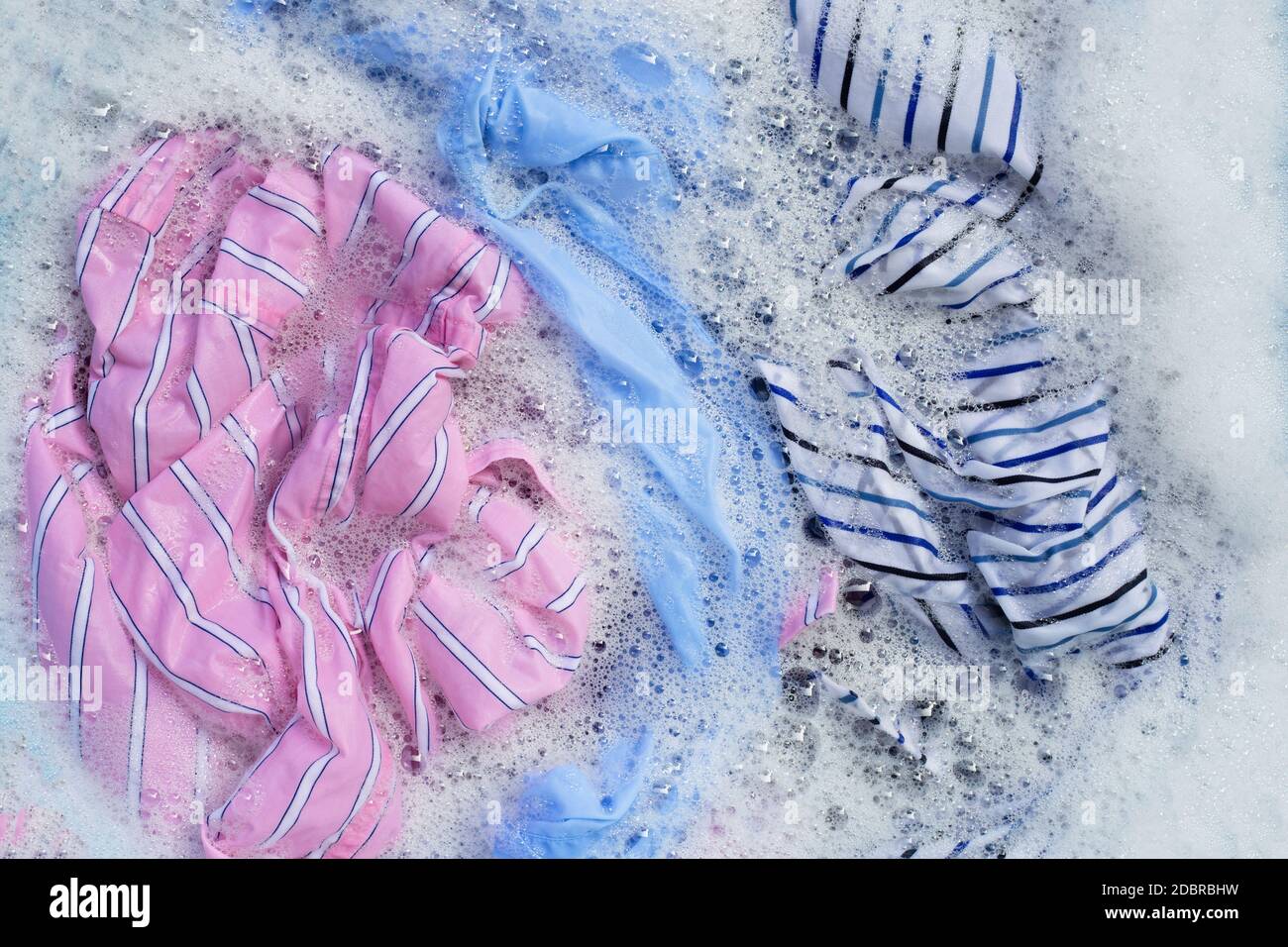 Top view of color clothes soak in powder detergent water dissolution ...