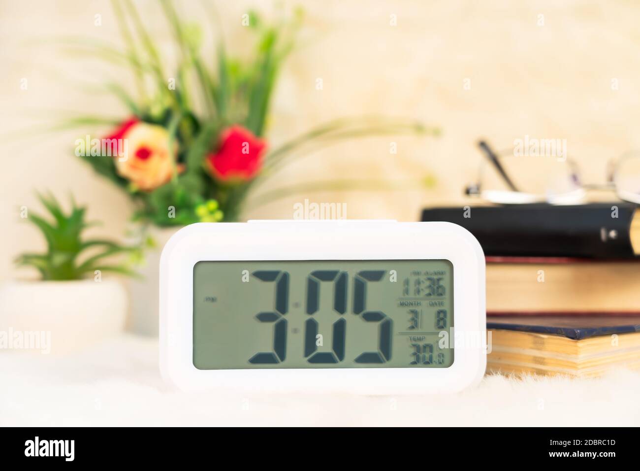 Close up Digital clock with book stacked on table Stock Photo - Alamy