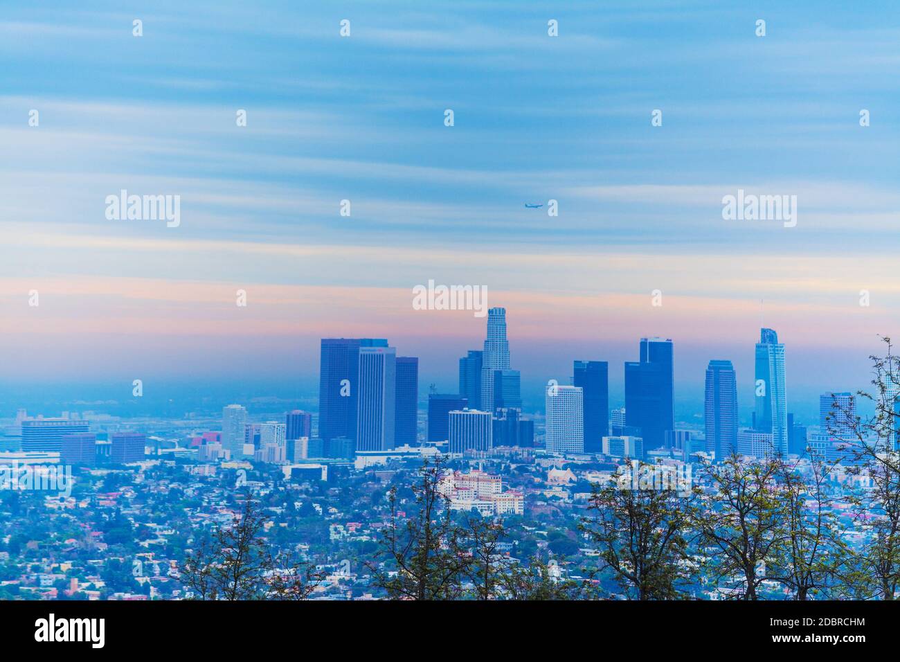 Airplane flying over downtown Los Angeles at dawn, California Stock ...