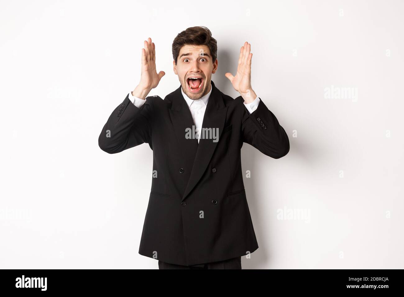 Frustrated and concerned man in black suit, screaming in panic and ...