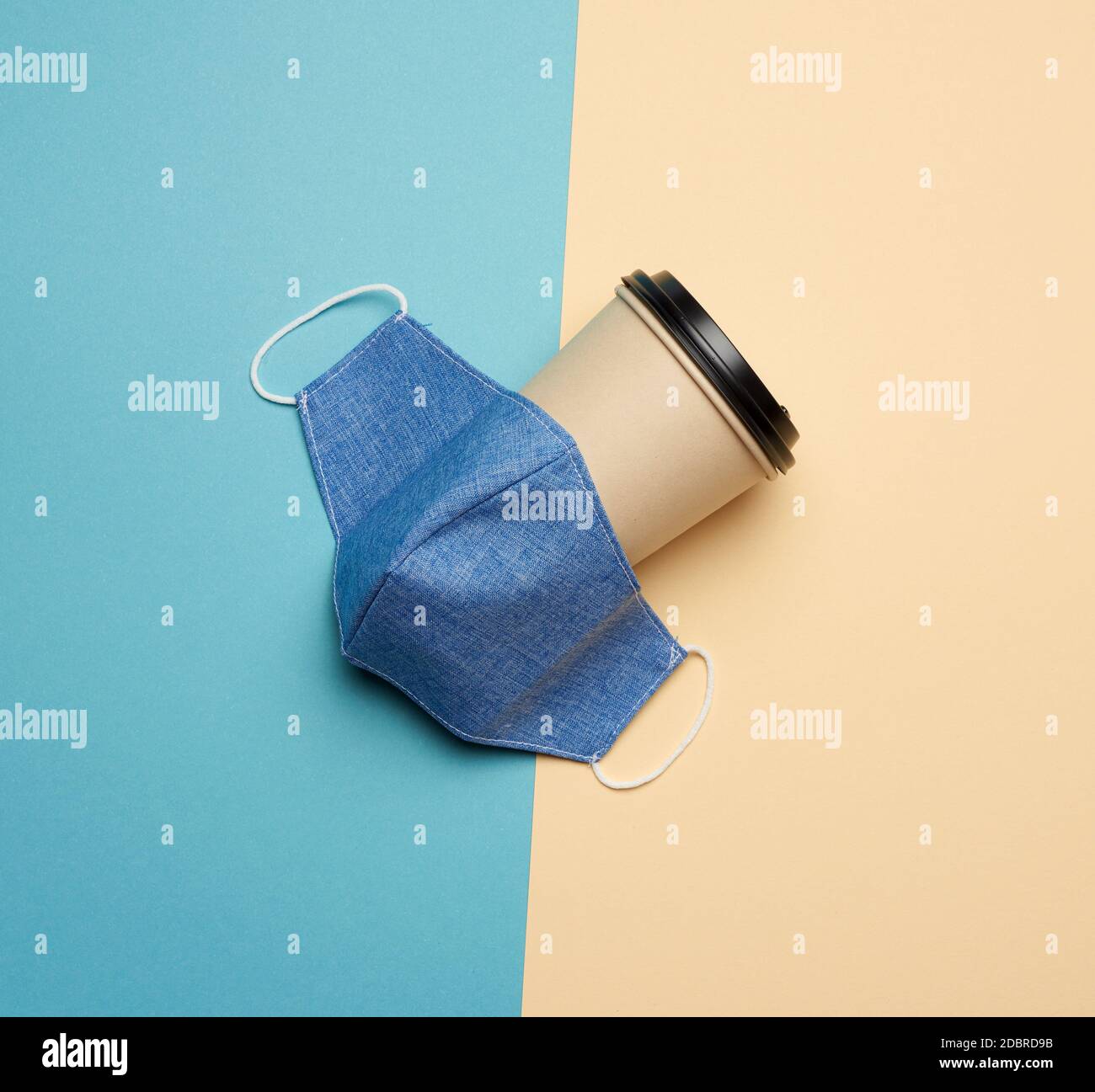 brown paper cup and blue reusable mask on a blue background, homemade ...