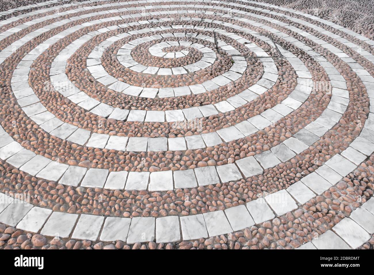 Pebbles mosaic floor with spiral pattern. Ornament out of white and ...