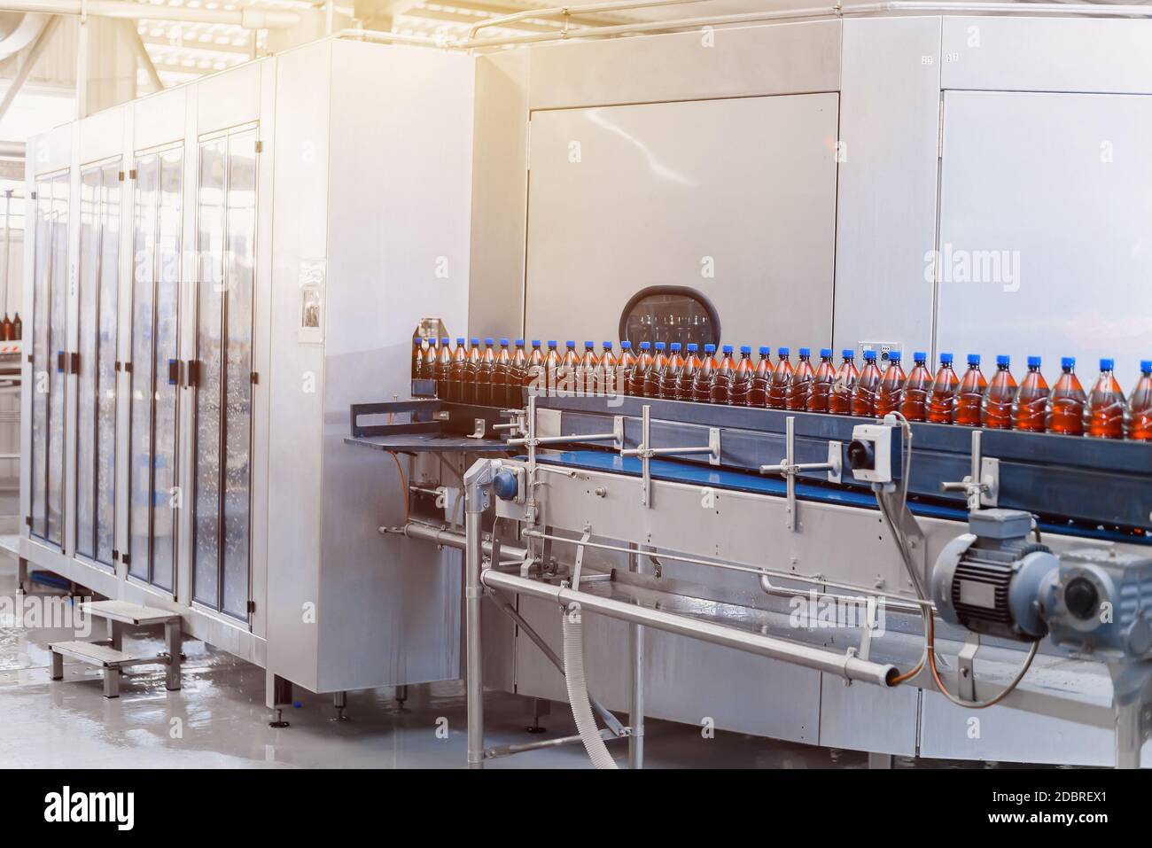 Row of brown beer plastic bottles on beer filling conveyor line Stock ...