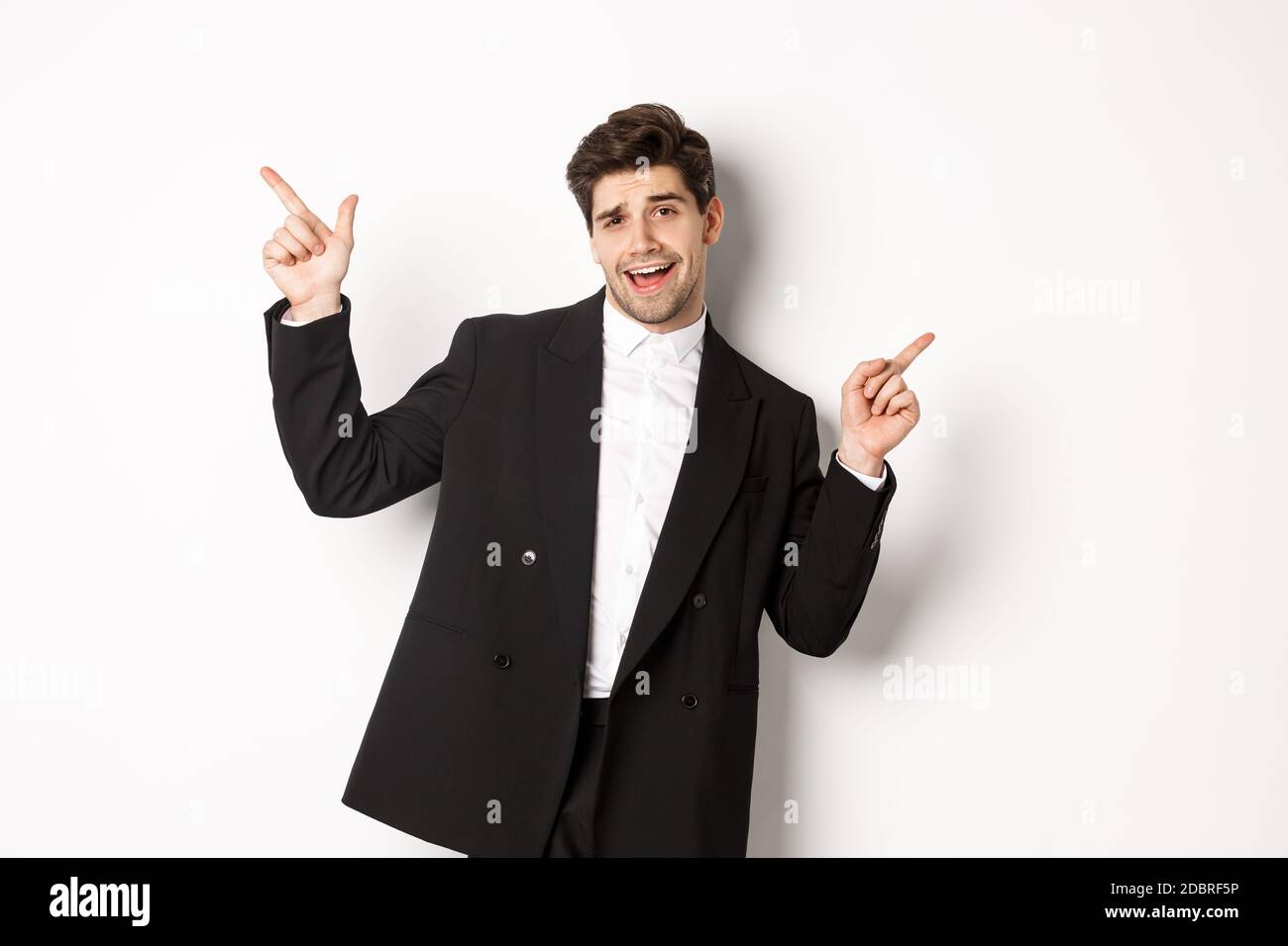 Handsome guy dancing and partying in black suit, pointing fingers ...