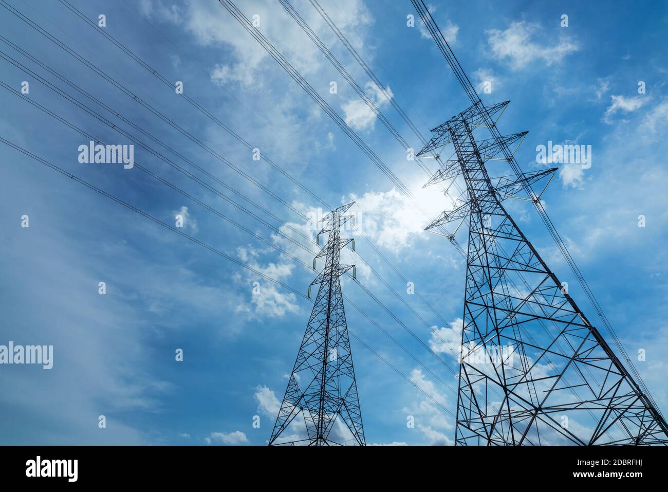 High voltage electric pylon and electrical wire against blue sky and ...
