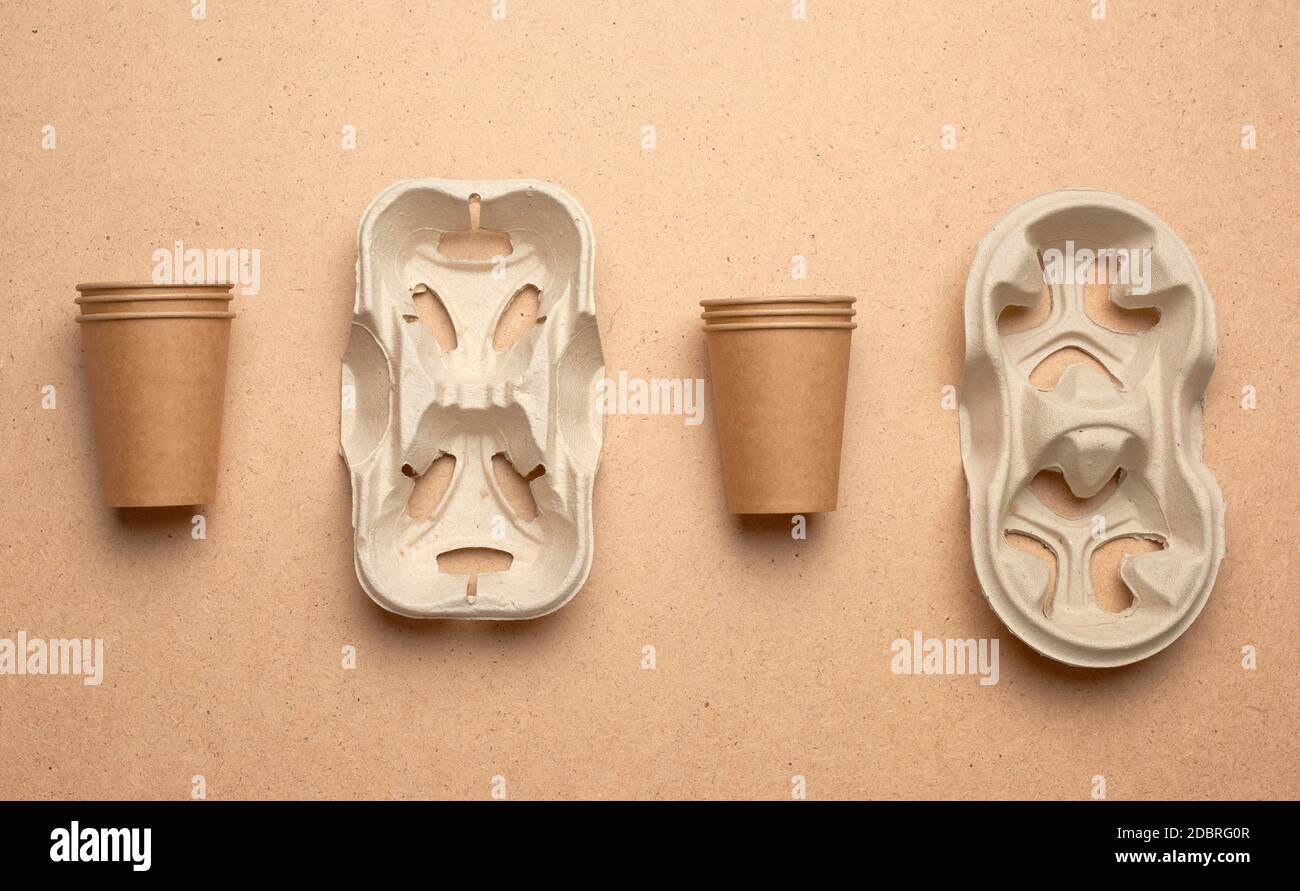 disposable brown paper craft cups and recycled paper holders on a brown ...