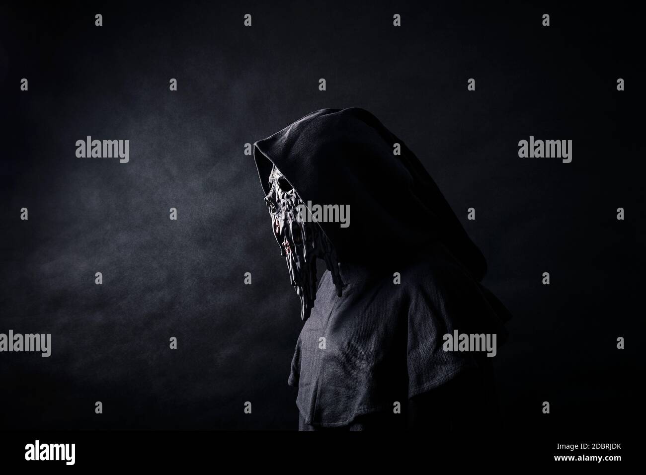 Scary figure in hooded cloak with mask Stock Photo - Alamy