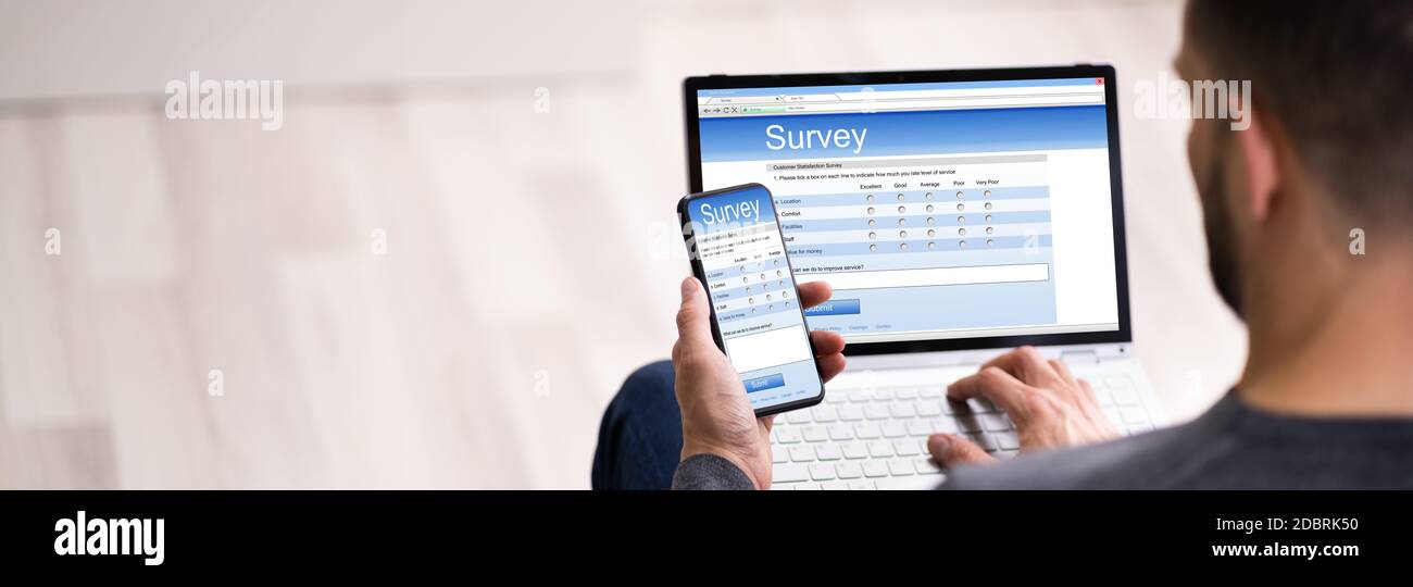 Close-up Of A Man Filling Online Survey Form On Laptop And Smartphone ...