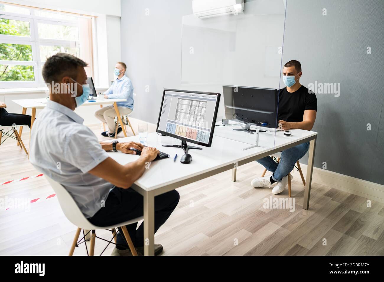 Business Employee Social Distancing Using Sneeze Guards In Office Stock ...