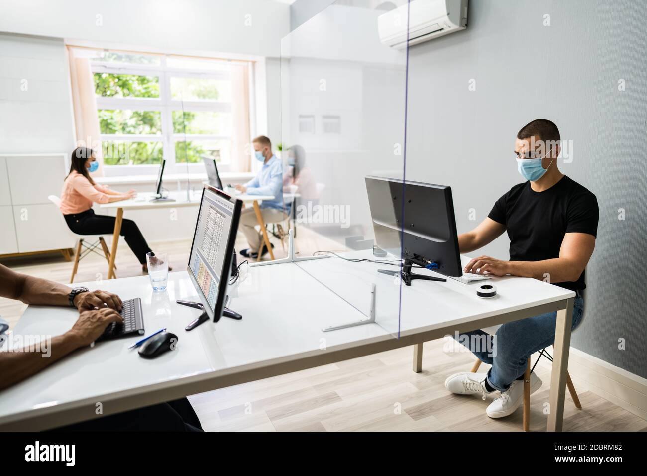 Business Employee Social Distancing Using Sneeze Guards In Office Stock ...