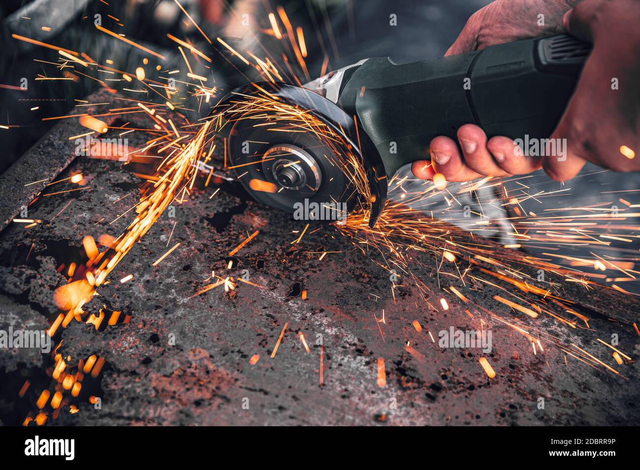 Sparks from the rotation and cutting of metal by electric saw machine ...