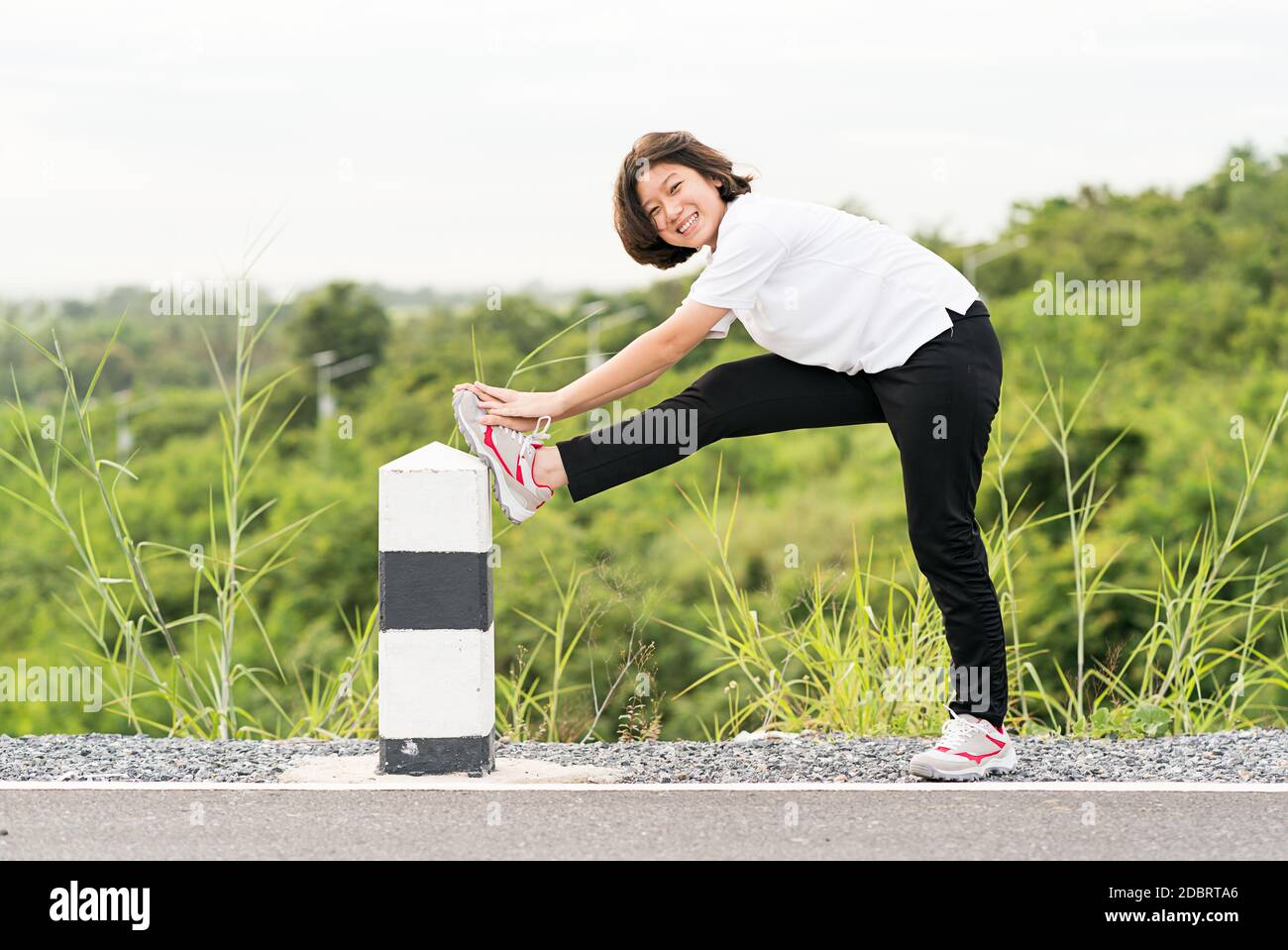 Woman runner doing exercises and warm up preparing for jogging outdoor ...
