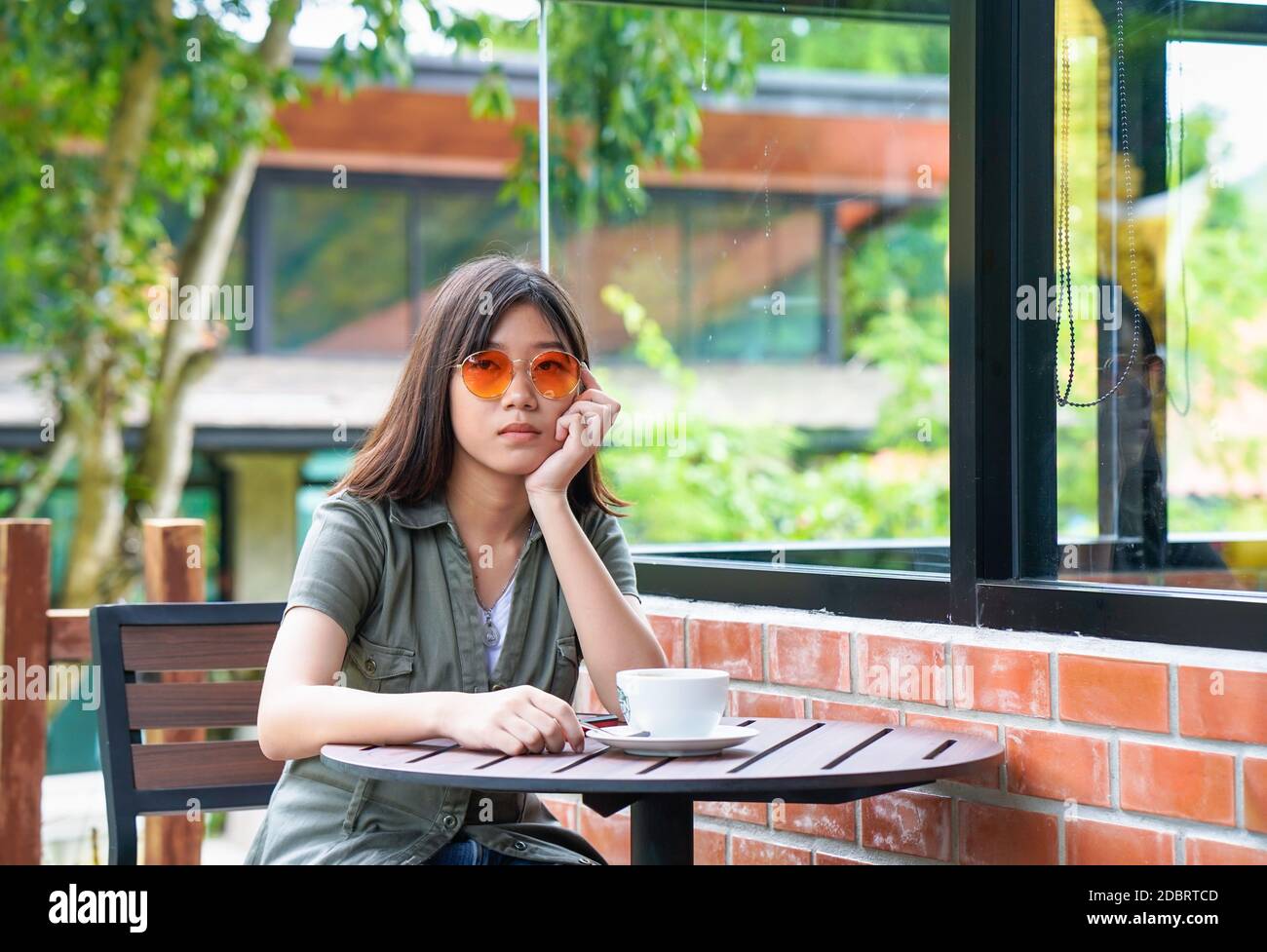 Pretty woman sitting in a cafe terrace with coffee cup Stock Photo - Alamy