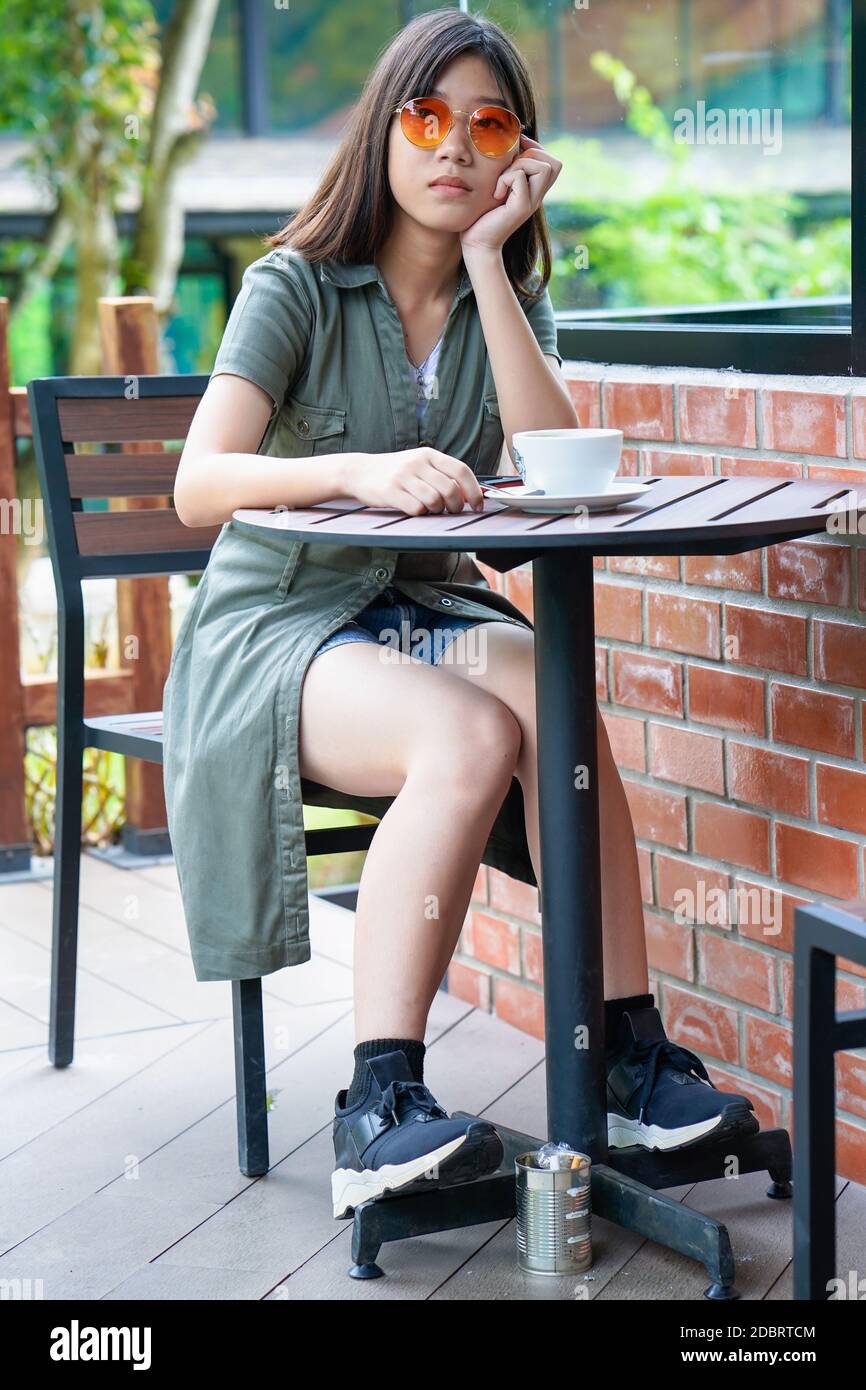 Pretty woman sitting in a cafe terrace with coffee cup Stock Photo - Alamy