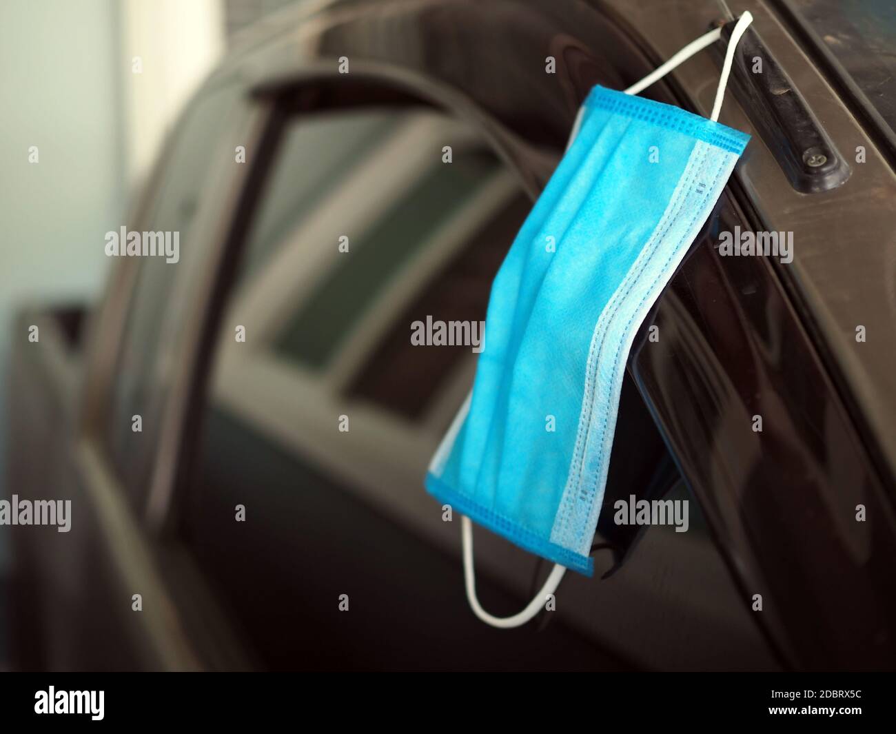 A face mask hanging from the side of the car door. To prepare at all ...