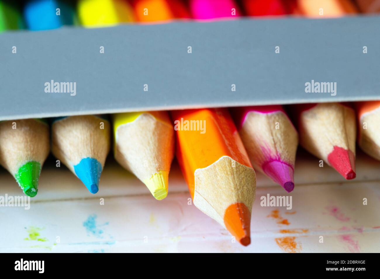 Colored pencils in a carton grey box, rainbow colors, orange pencil ...