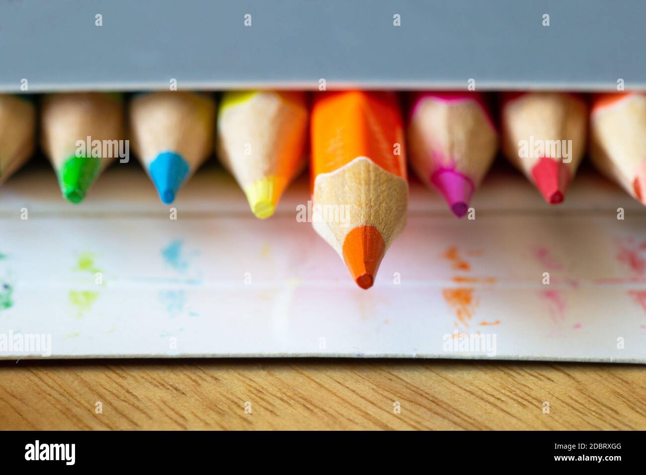 Colored pencils in a carton grey box, rainbow colors, orange pencil ...