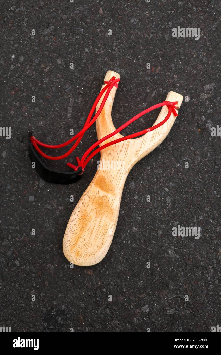 Simple slingshot isolated, wooden handle with two red rubber bands ...