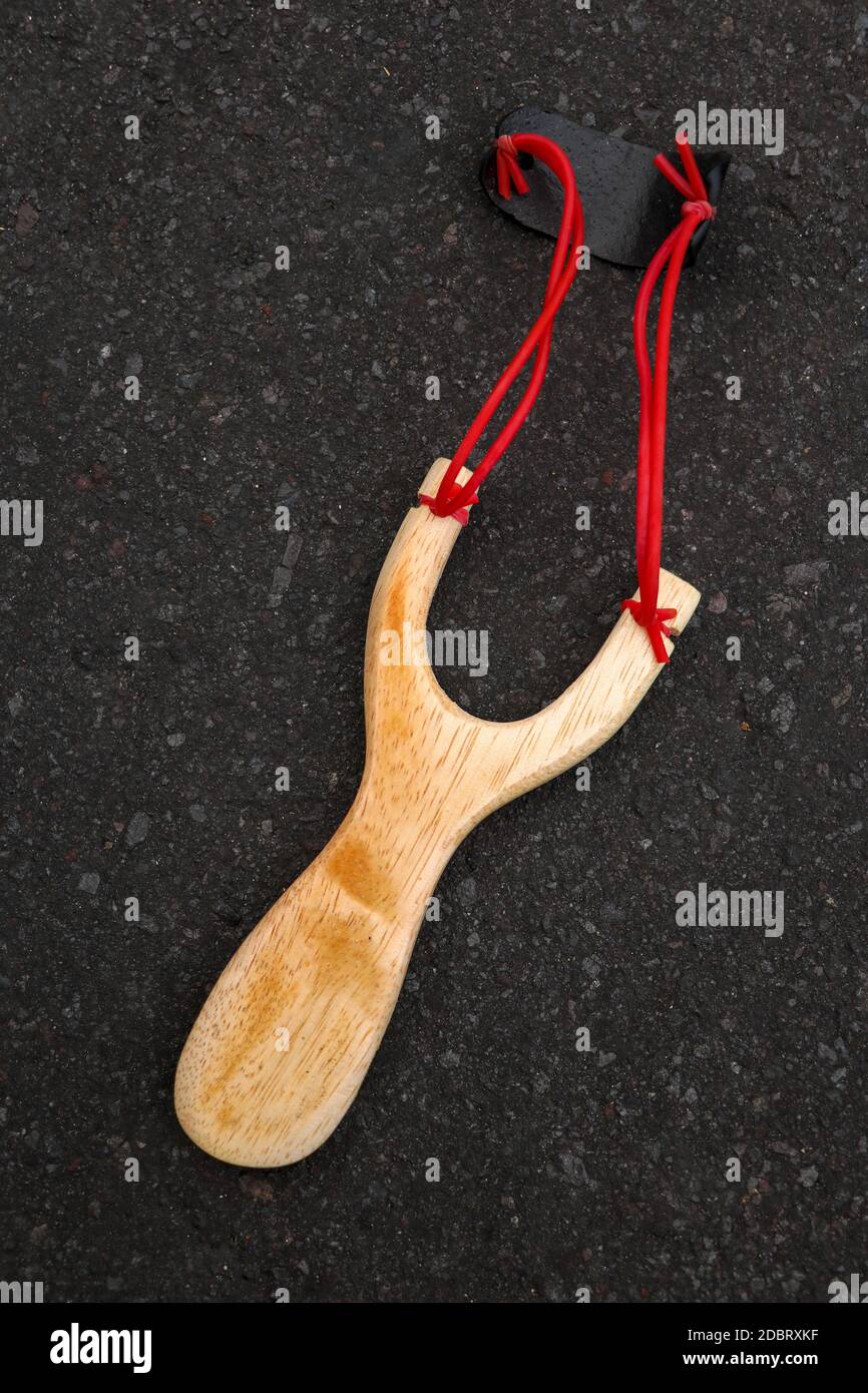 Simple slingshot isolated, wooden handle with two red rubber bands ...