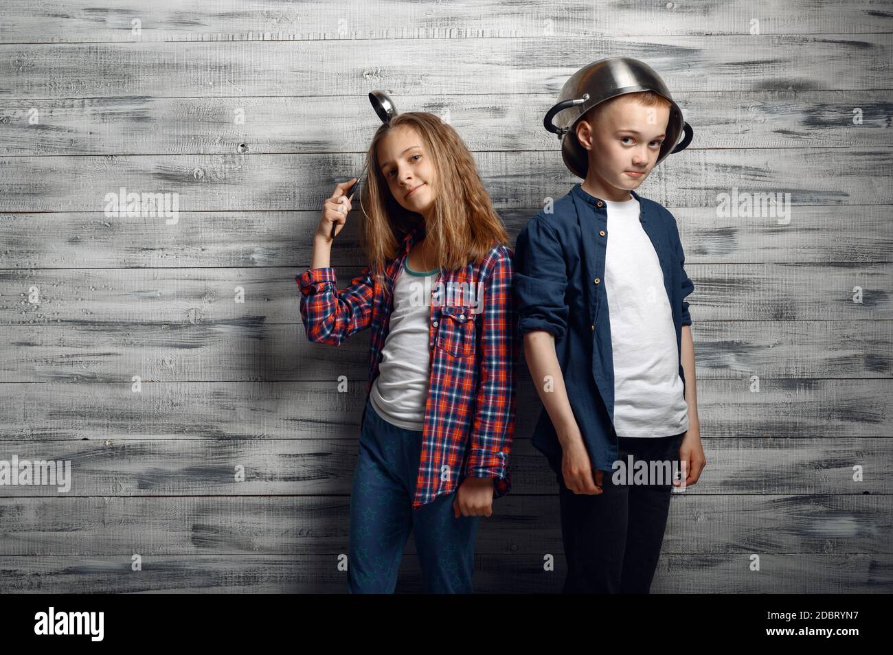 Little boy and girl poses with pot and the ladle in studio. Children ...