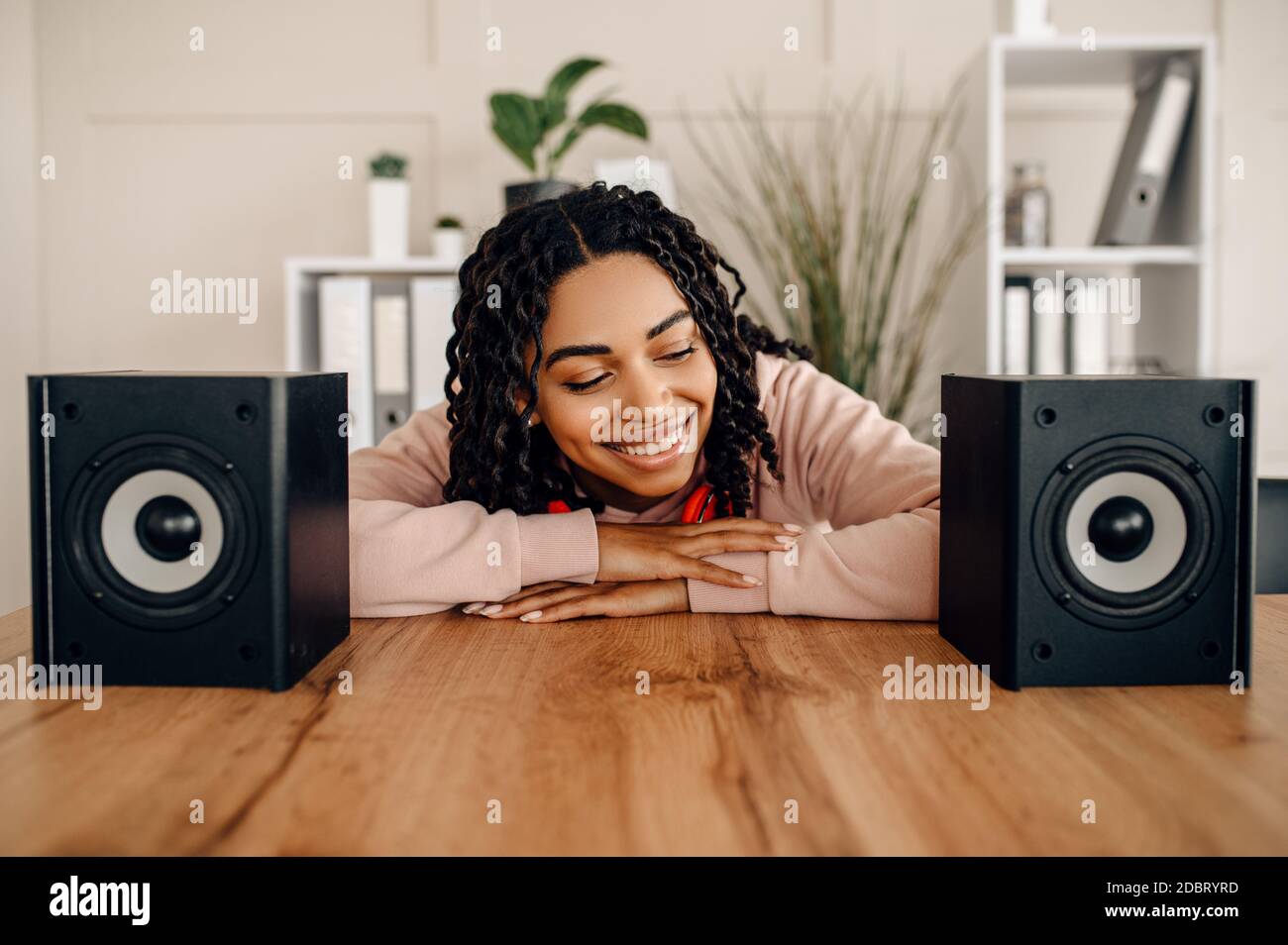 Cute woman between two audio speakers listen to music. Pretty lady ...