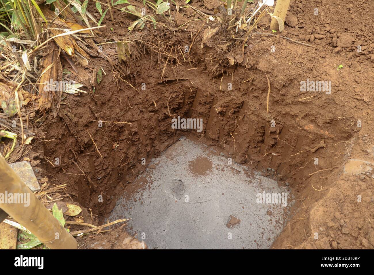 Square, one meter deep hole in the ground with concrete bottom. Hole ...