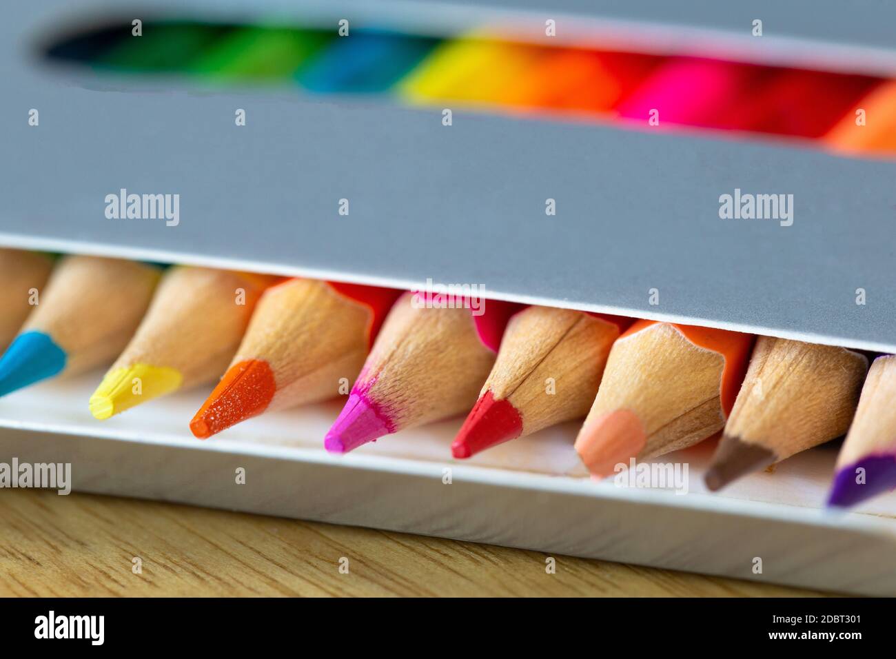 Colored pencils in a carton grey box, rainbow colors, orange pencil ...