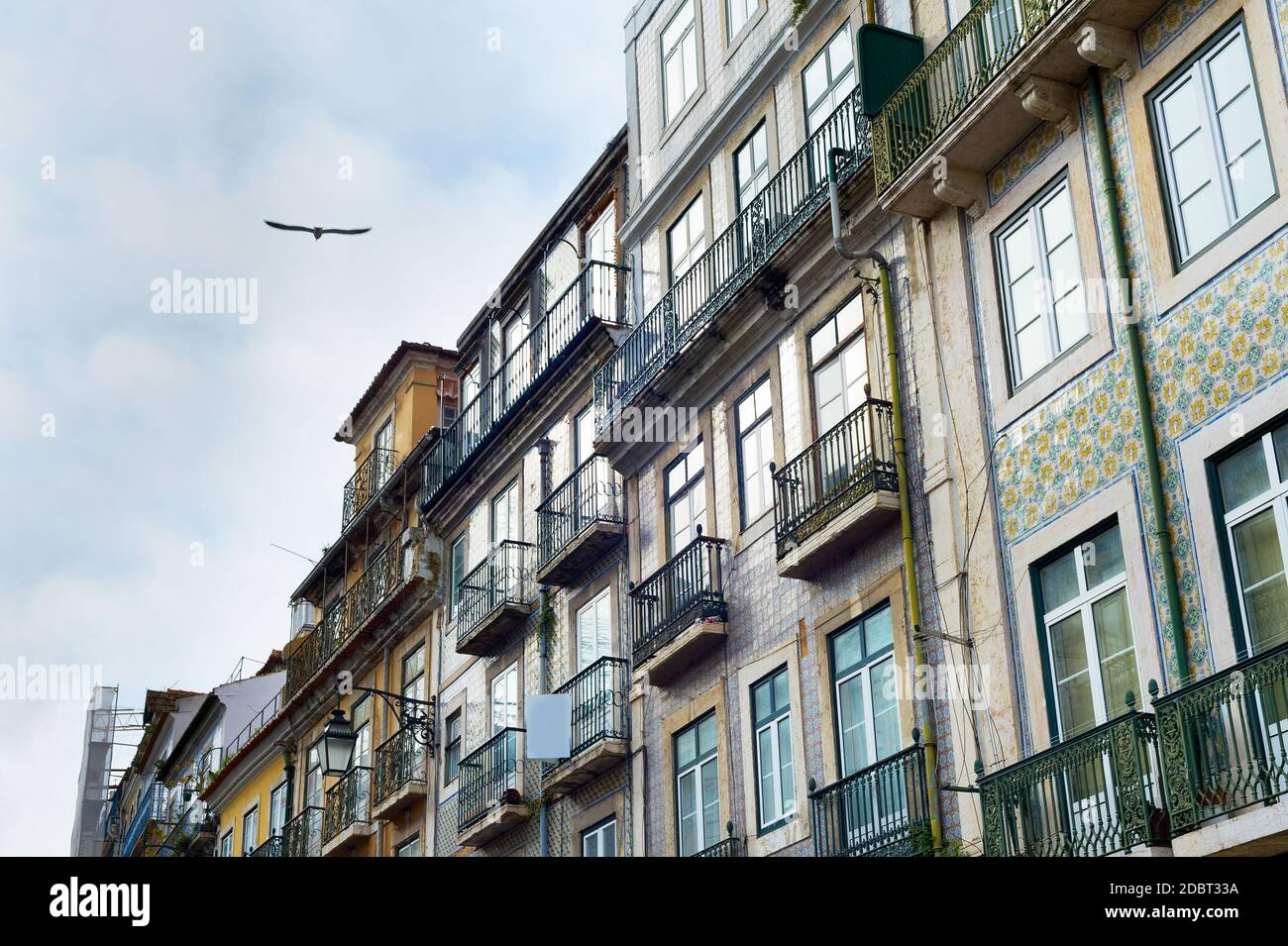 Typical portugese street with traditional tiled architecture under ...
