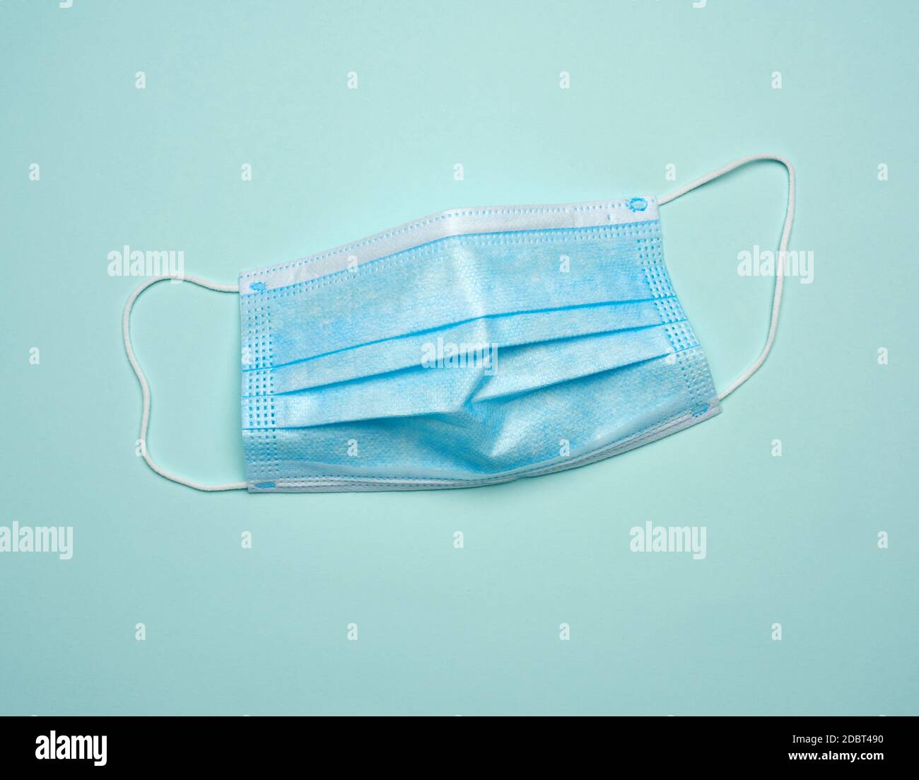 blue disposable medical mask on a blue background, personal protective ...