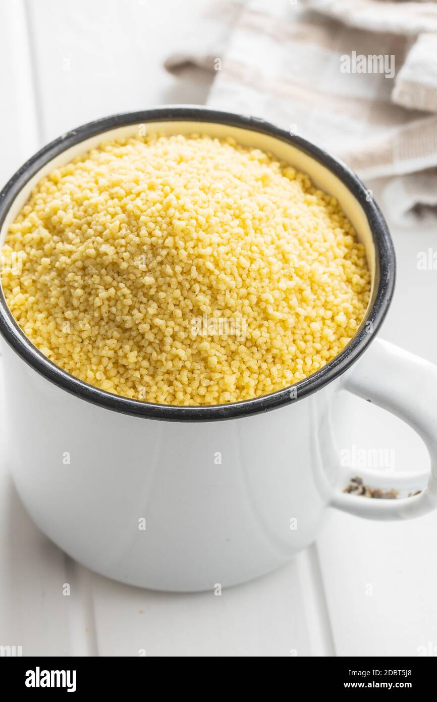 Dry yellow couscous in metal mug Stock Photo - Alamy